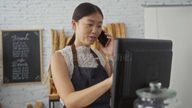 Young Woman Working in a Bakery Shop, Using a Computer Terminal while ...