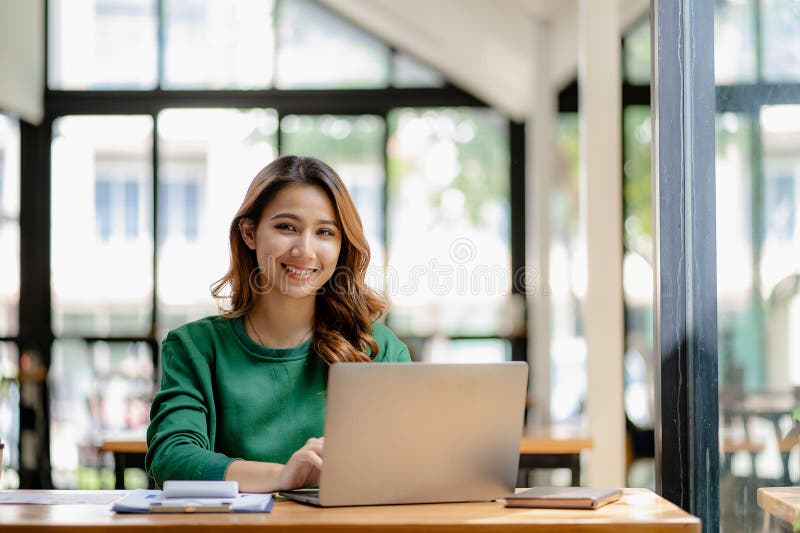 Young Woman Working in a Cafe Using Laptop and Drinking Coffee Asian ...