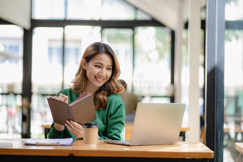 Young Woman Working in a Cafe Using Laptop and Drinking Coffee Asian ...
