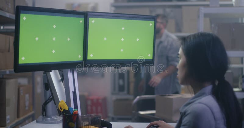 Young Woman Working at a Computer in a Distribution Center Stock ...