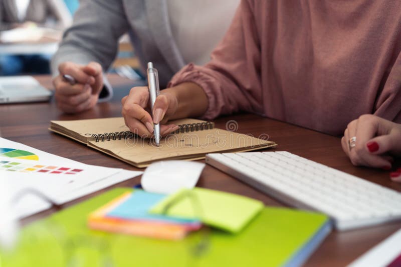 Young Woman Working at Her Desk Taking Notes. Focus on Hand Writing on ...