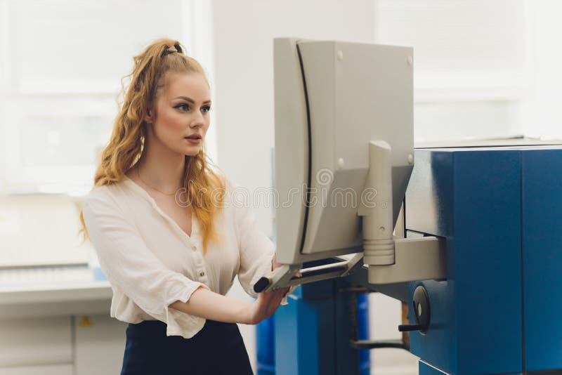 Young Woman Working in Printing Factory. Printing Press. Stock Photo ...