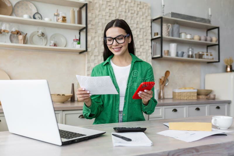 A Young Woman Works and Studies at Home Using a Laptop. she is Sitting ...