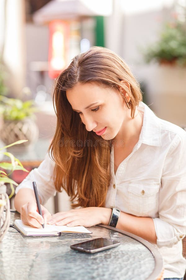 Young Woman Writing Down into Her Notebook Stock Photo - Image of ...