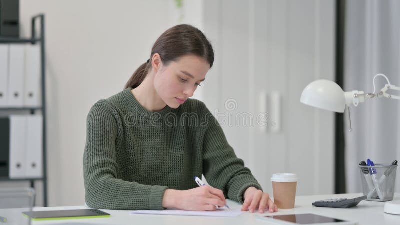 Young Woman Writing on Paper at Work Stock Photo - Image of signature ...