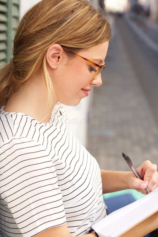 Young Woman Writing with Pen in Book Stock Photo - Image of outside ...