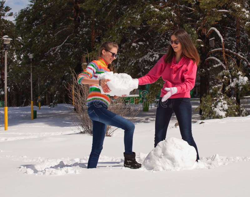 Young women build snowman stock photo. Image of enjoyment - 19375596