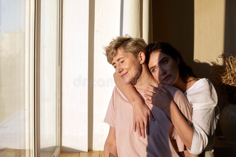 Lesbian Couple Enjoying Sunlight Near Window Stock Image Image Of