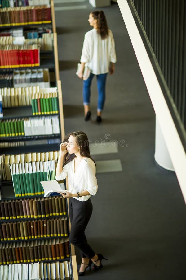 Young women in the library stock photo. Image of standing - 60412140