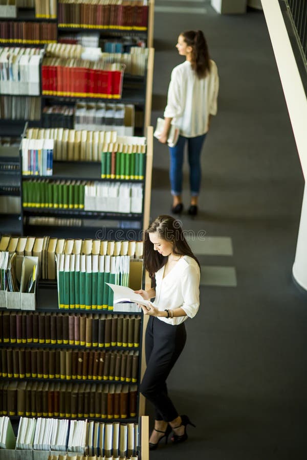 Young women in the library stock photo. Image of books - 60929948