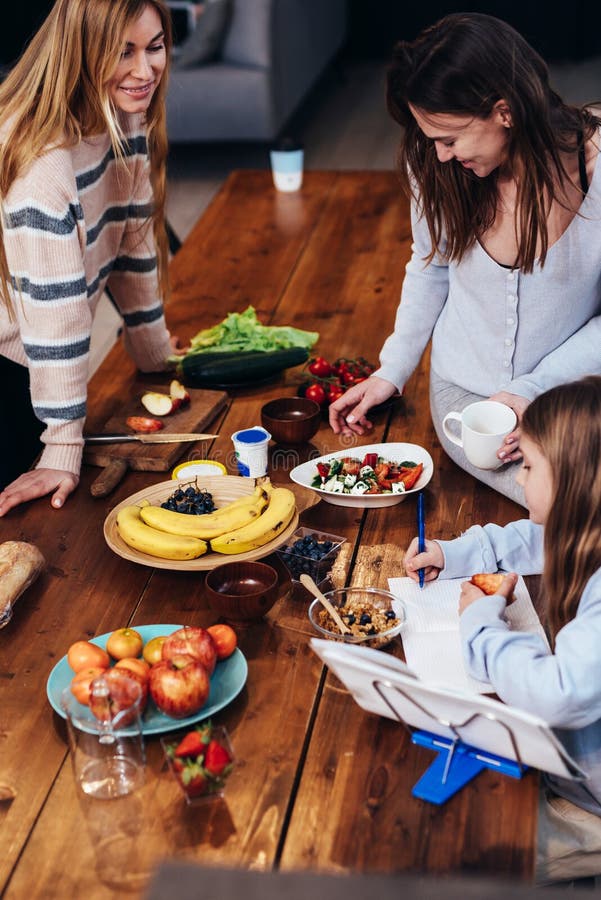 Young Women Set the Table, Girl Does Her Homework Stock Photo - Image ...