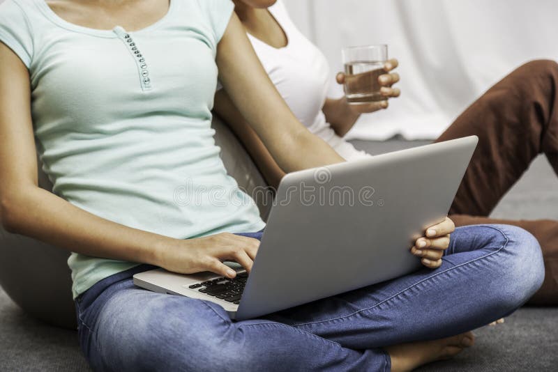 Young Women Sitting while Using Laptop Stock Image - Image of ...