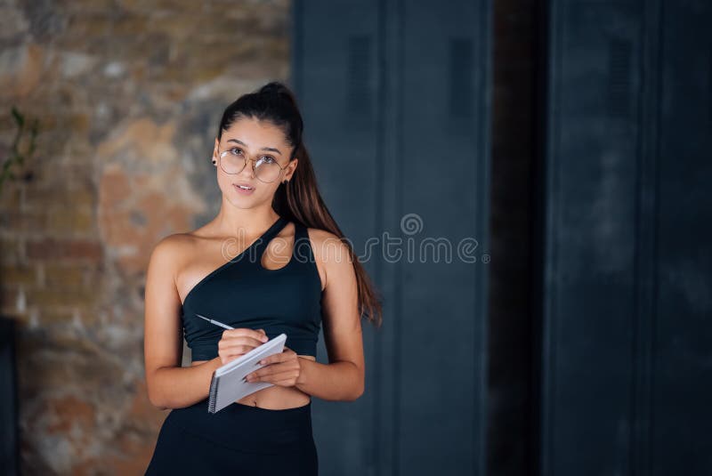 Young Women Standing Writing Down Something into the Notebook. Stock ...