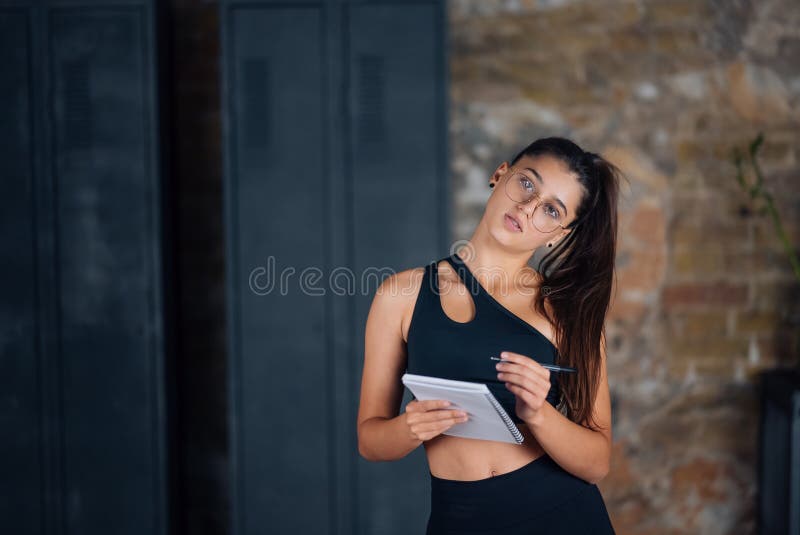 Young Women Standing Writing Down Something into the Notebook. Stock ...
