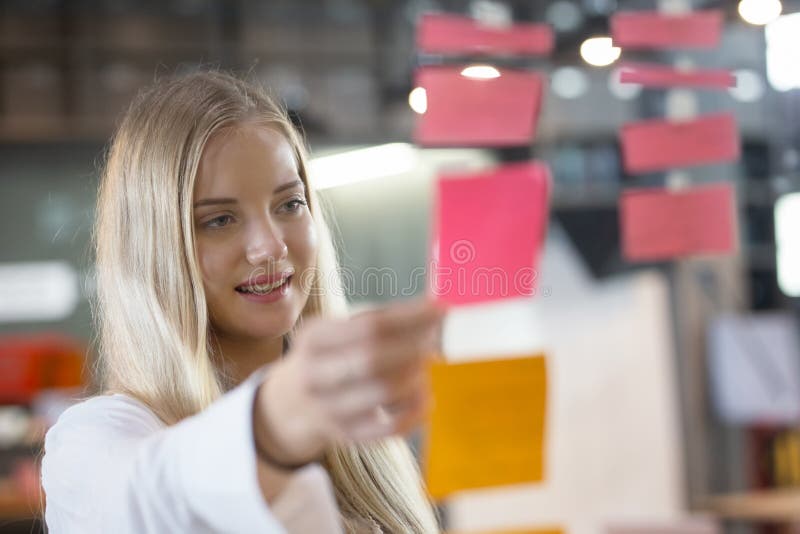 Young Women Sticking Post-its on an Idea Board. Brainstorming and ...