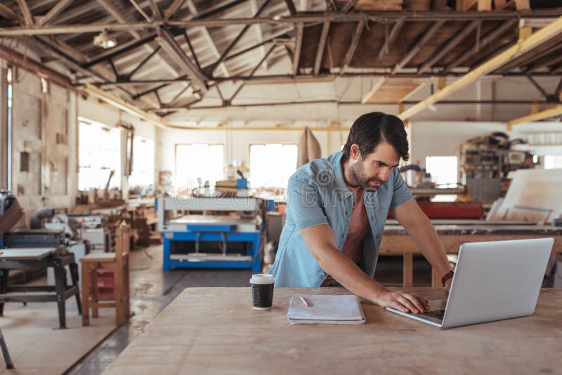 Young Woodworker Using a Laptop in His Workshop Stock Image - Image of ...