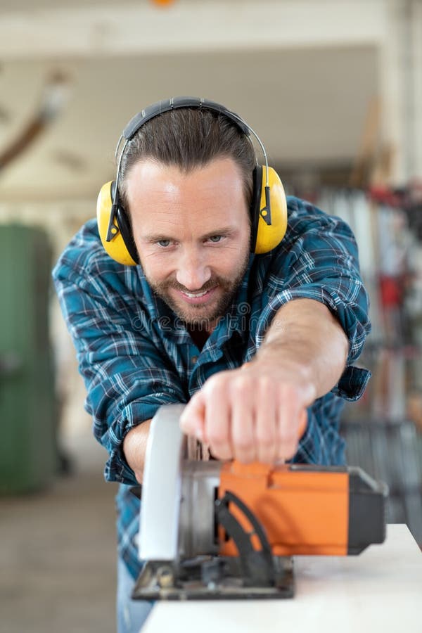 Young Worker in a Carpenter`s Workshop with Hand Saw Stock Photo ...