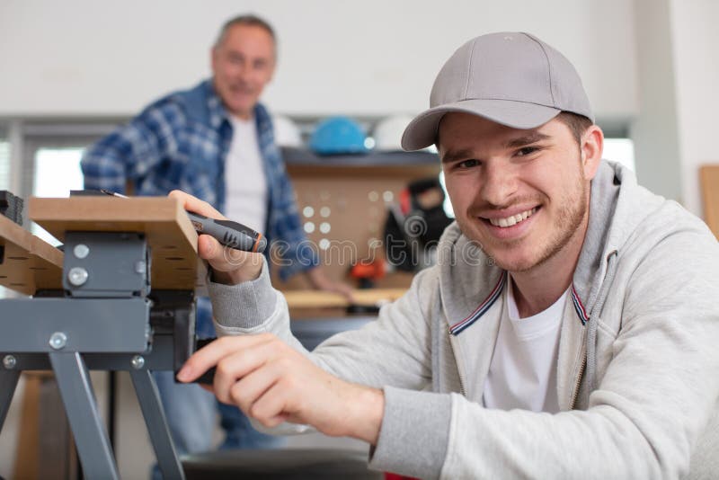 Young worker fixing table stock photo. Image of home - 241148354
