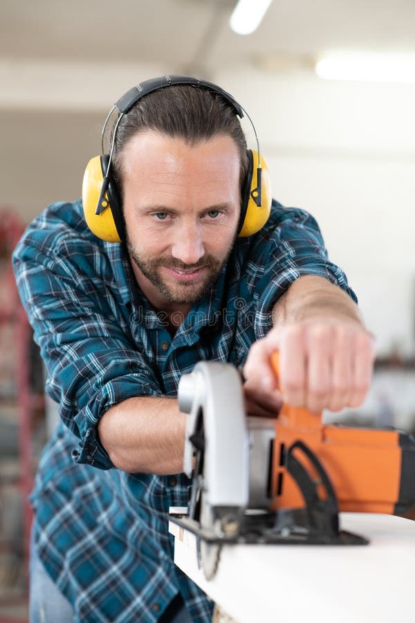 Young Worker in a Carpenter`s Workshop with Hand Saw Stock Photo ...