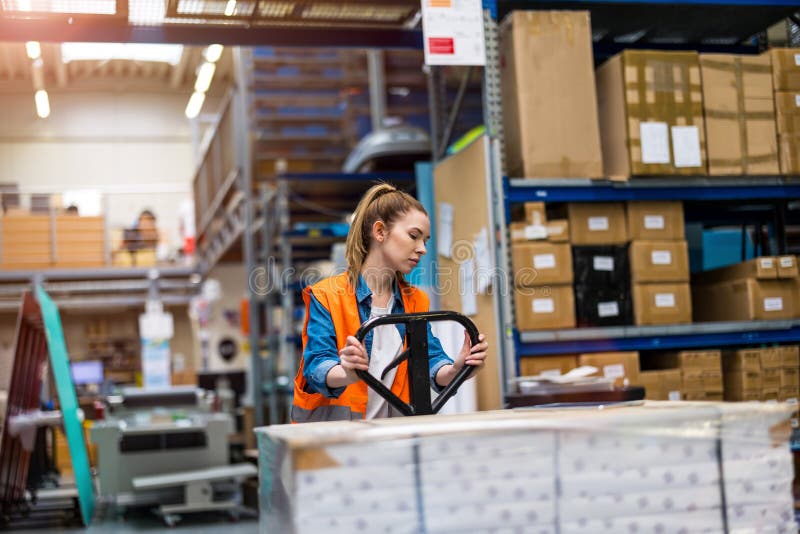 Young Worker Moving Goods on Pallet Jack at Warehouse Stock Photo ...