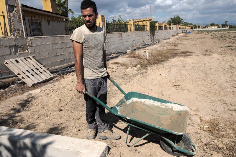 Young Worker Transporting Materials with a Wheelbarrow Stock Photo ...