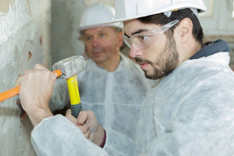 Young Worker Using Hammer and Chisel Senior Worker Watching Stock Photo ...