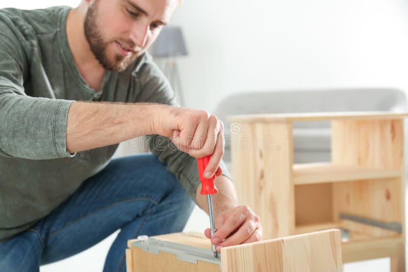 Young Working Man Repairing Drawer at Home, Space for Stock Image ...