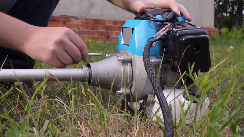 Young Man Assembling Parts of the String Trimmer. Stock Photo - Image ...