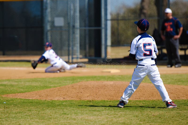 Youth Pitcher after Throw To First Stock Photo - Image of league ...