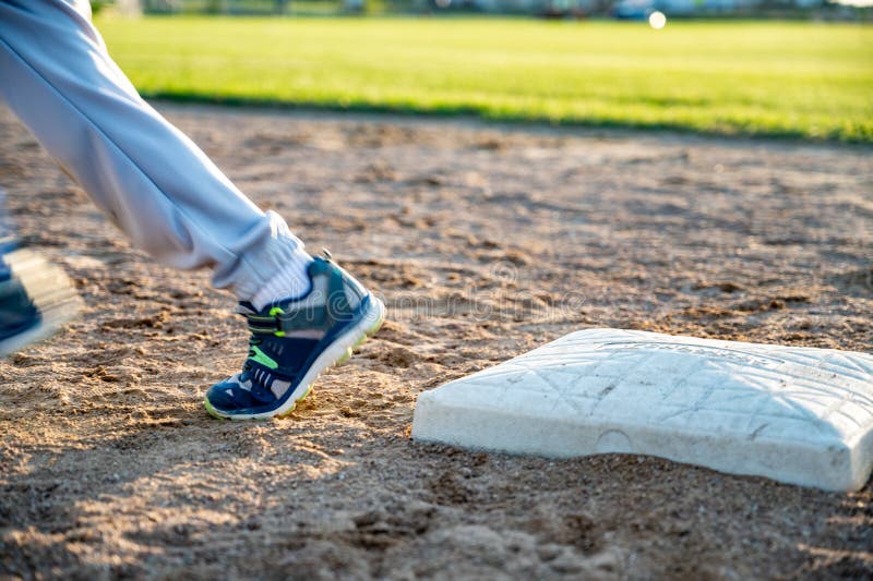 Youth Baseball with a Runner Taking Off for the Next Base Stock Photo ...