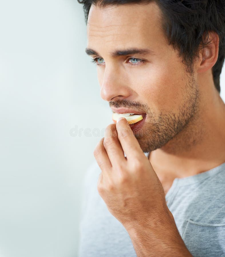 Yummy...a Handsome Young Man Eating a Slice of Apple. Stock Photo ...