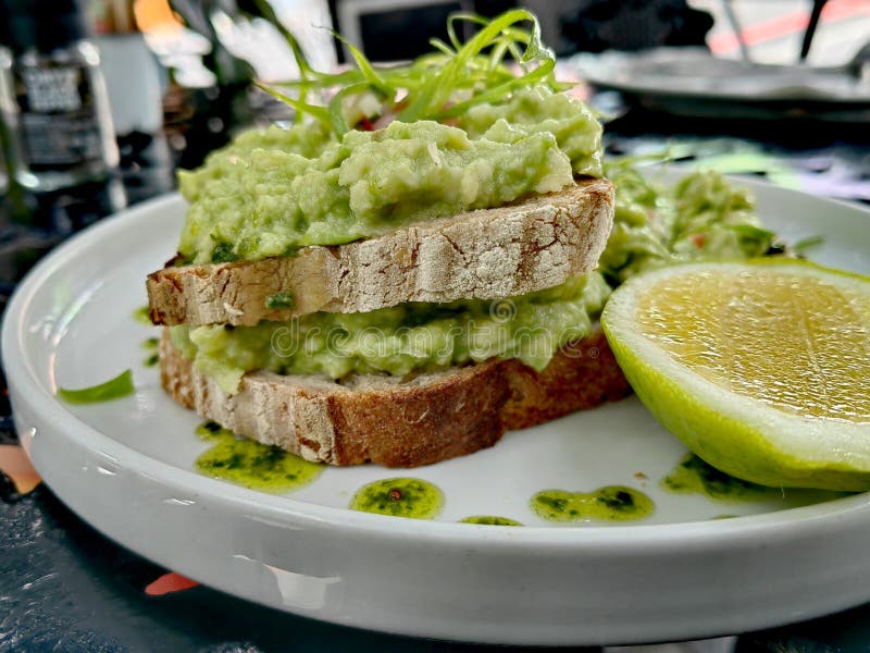 Yummy Smashed Avocado Toast with Lemon Slice on the Side! Stock Photo ...