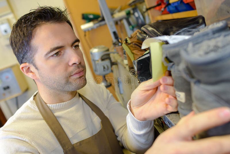 Zapatero recoge zapato foto de archivo. Imagen de habilidad - 258547106
