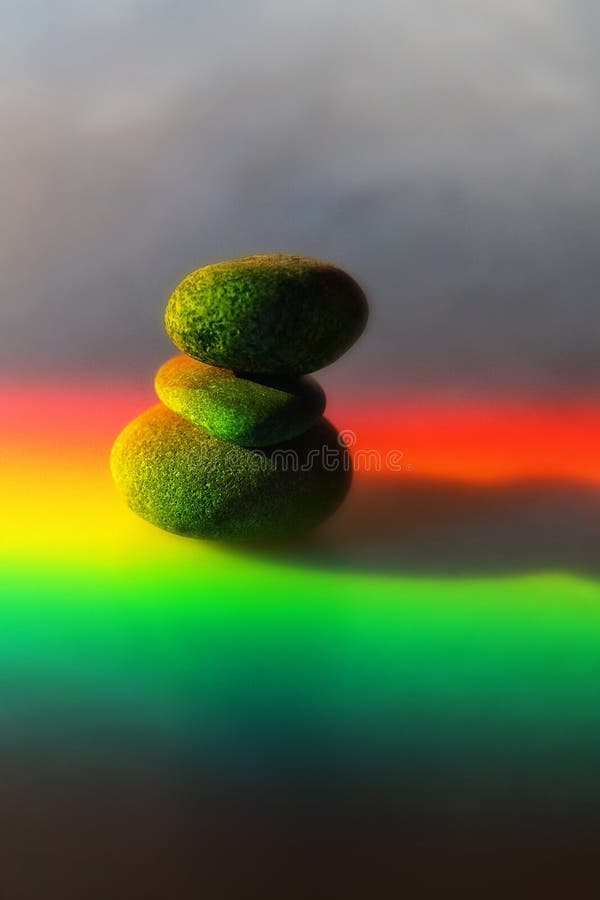 Zen Stone in Touch of Rays of Color Stock Photo - Image of pebble ...