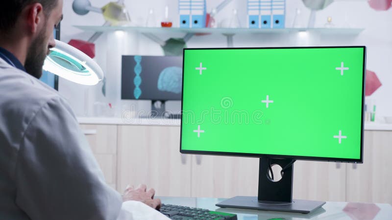 Zoom in Shot of Doctor Working on Computer with Green Screen Mock-up ...
