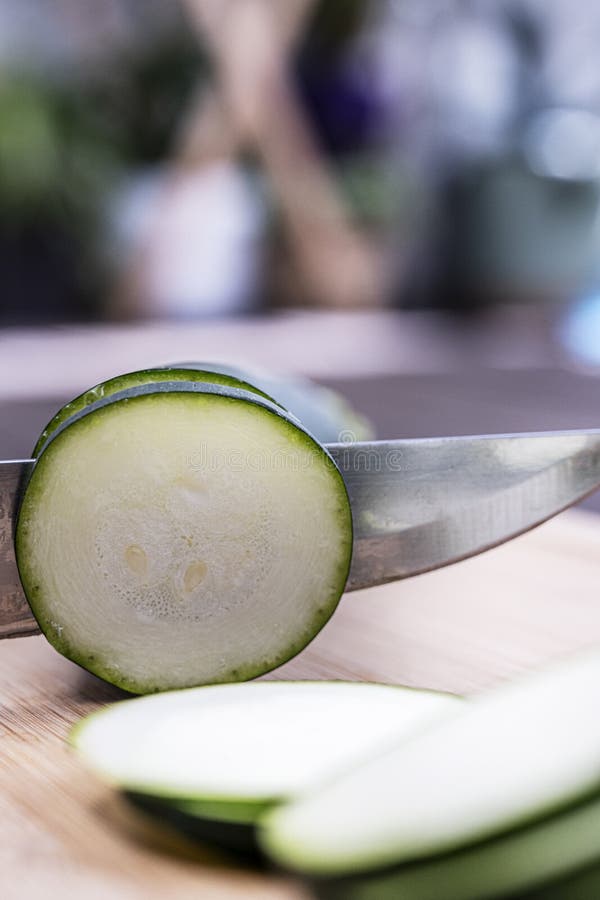 Zucchini Cut into Many Thin Slices with a Sharp Knife on a Bamboo Board ...