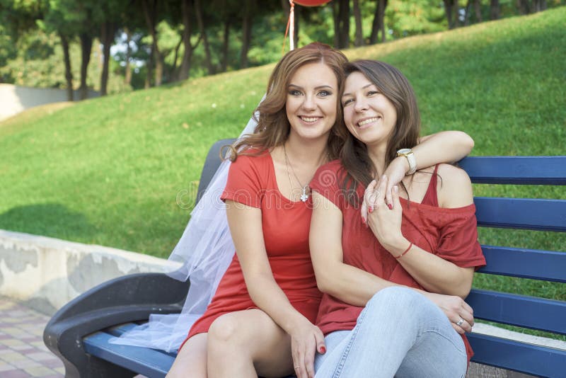 Zwei Freundinnen, Die Auf Der Bank Sitzen Stockbild - Bild von rasen ...
