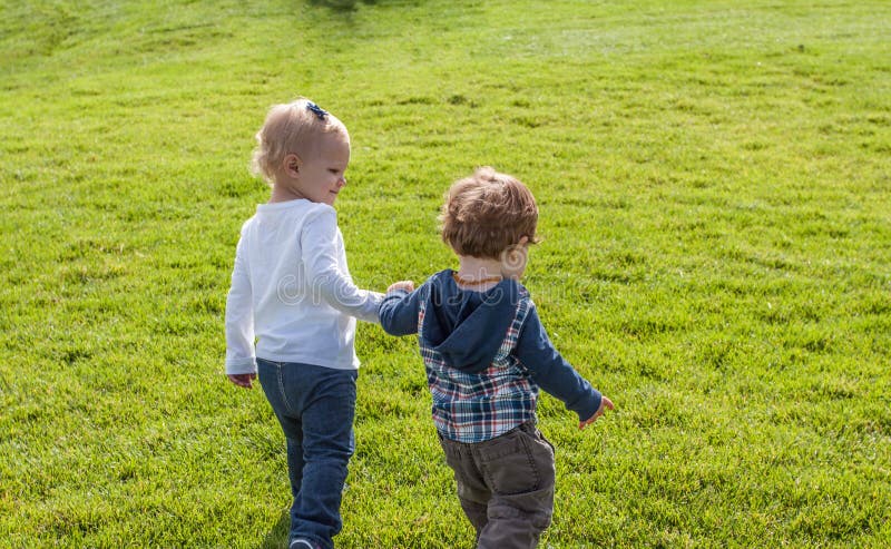 Zwei Kleinkinder, Hand in Hand Gehend in Gras Stockfoto - Bild von ...