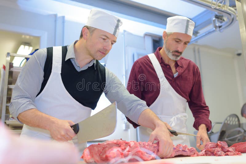 Zwei Metzger, Die Fleisch Im Shop Zubereiten Stockfoto - Bild von ...