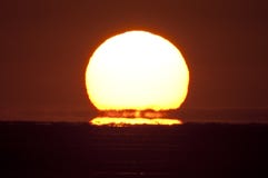 A Half Sun Shows Over Ocean At Sunrise Stock Image - Image of orange ...