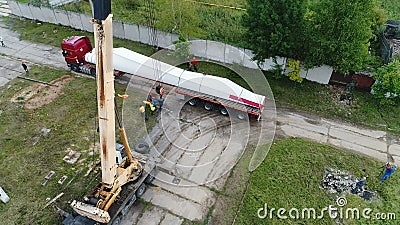 From Above we See a Truck with a Large Load Pulling Under a Crane ...