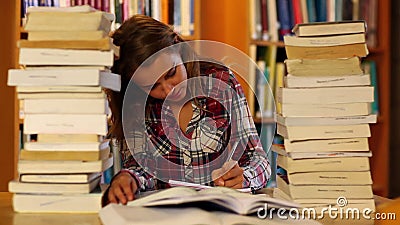 Attentive Student Studying and Taking Notes in the Library Surrounded ...