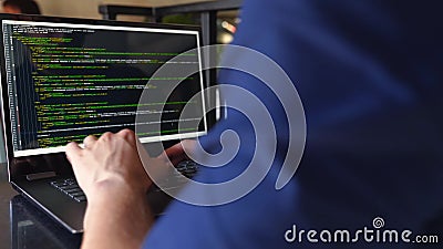 Back View Over the Shoulder Shot of Developer Programmer with Laptop. Program Code and Script ...