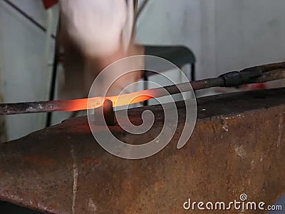 Blacksmith Hitting Hot Metal with a Hammer on an Anvil Inside His ...