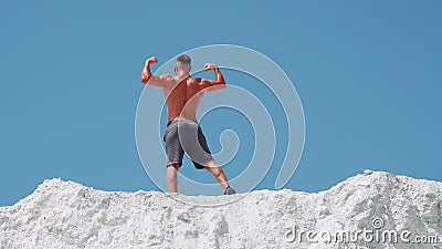 Bodybuilder Athlete Posing with Muscles in Nature Against a Blue Sky ...