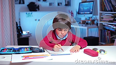 A Boy Sitting at a Table Doing a Drawing Task at School Stock Video ...