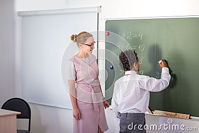 Boy Solving Addition And Subtraction On Board. Schoolboy Writing ...