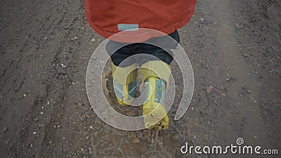 Boy Walks through the Puddles and Mud in the Spring. Stock Footage ...