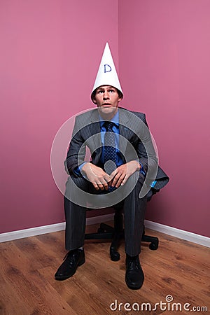 Businessman Sat In Corner Wearing Dunce Hat Royalty Free Stock Images ...