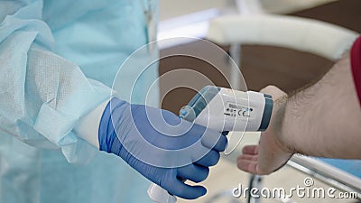 Checking the Temperature with a Non-contact Thermometer. a Nurse in ...